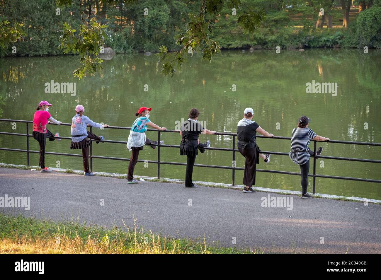 Chinese American women prepare for a group walk and stretch their leg ...
