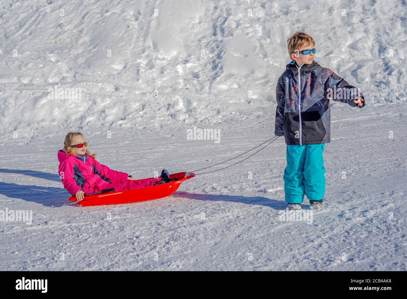 Brother pulling his sister kids toboggan sled snow. Little girl and boy ...