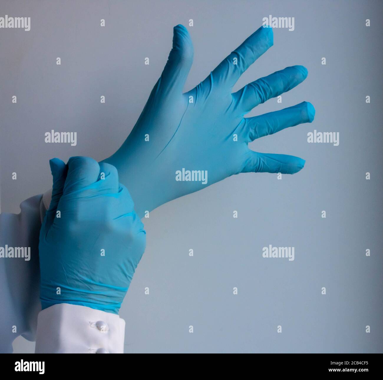 Science experiment - teenager in white lab coat and blue medical gloves ...