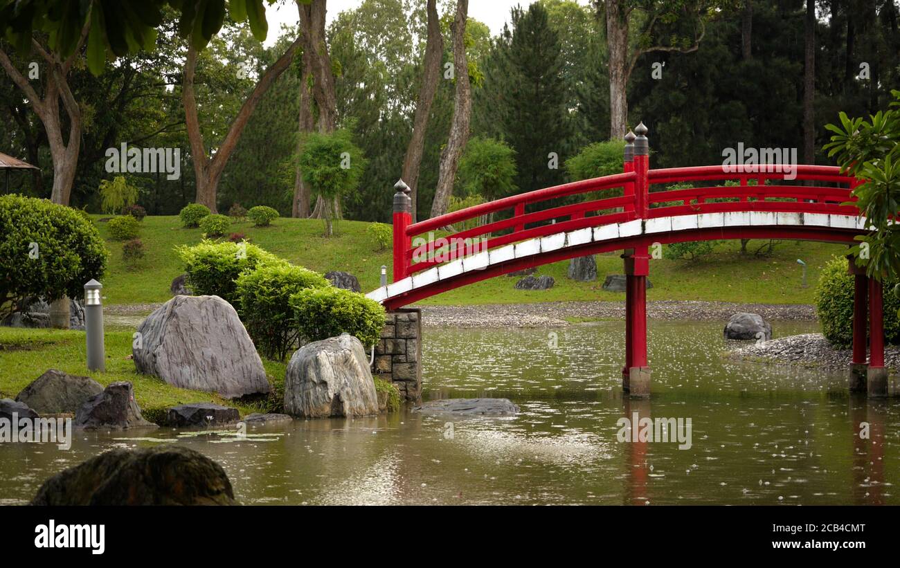 Beautiful scenery of a red footbridge under the sunlight Stock Photo ...
