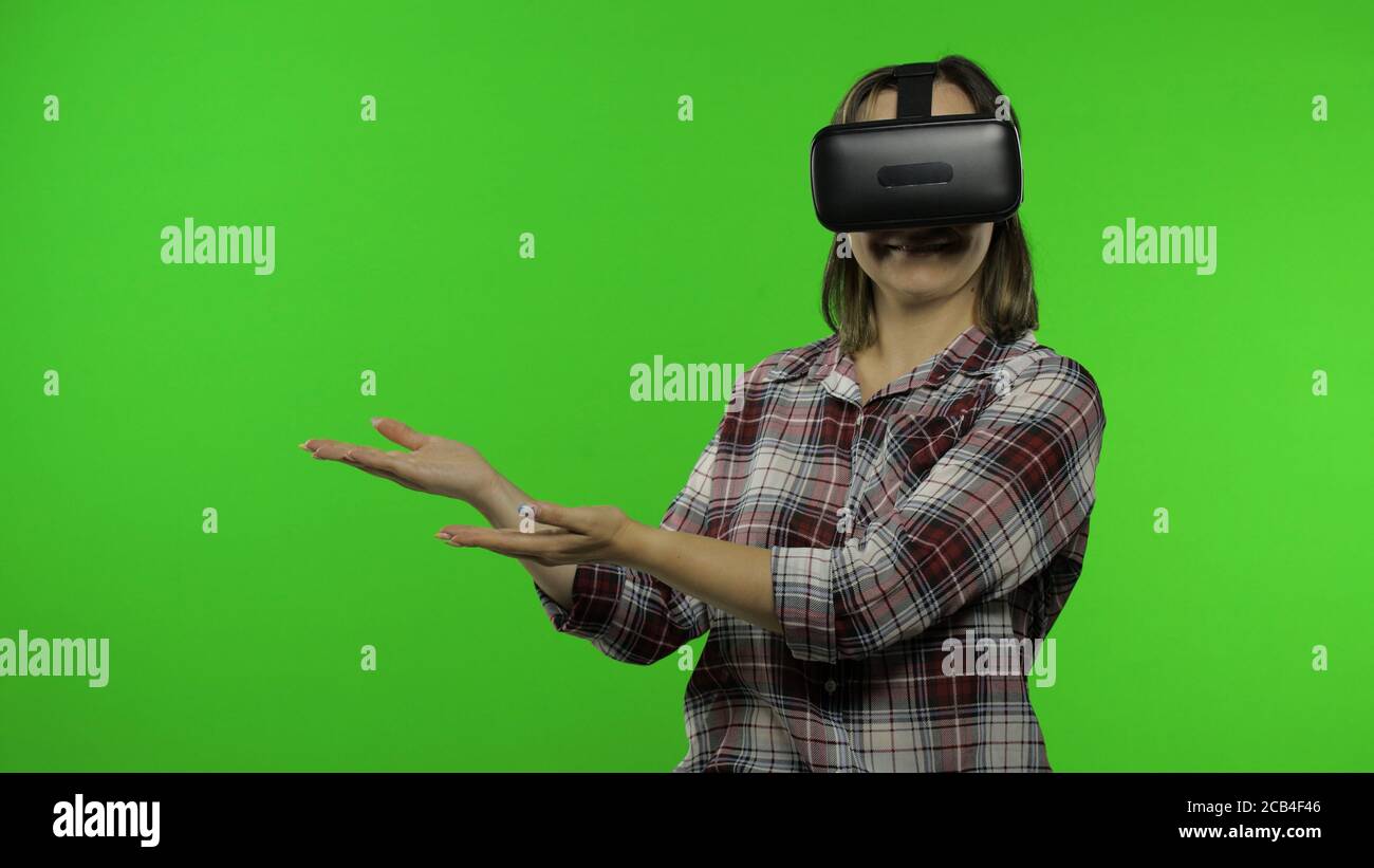 Young woman using VR headset helmet to play game, showing side ...