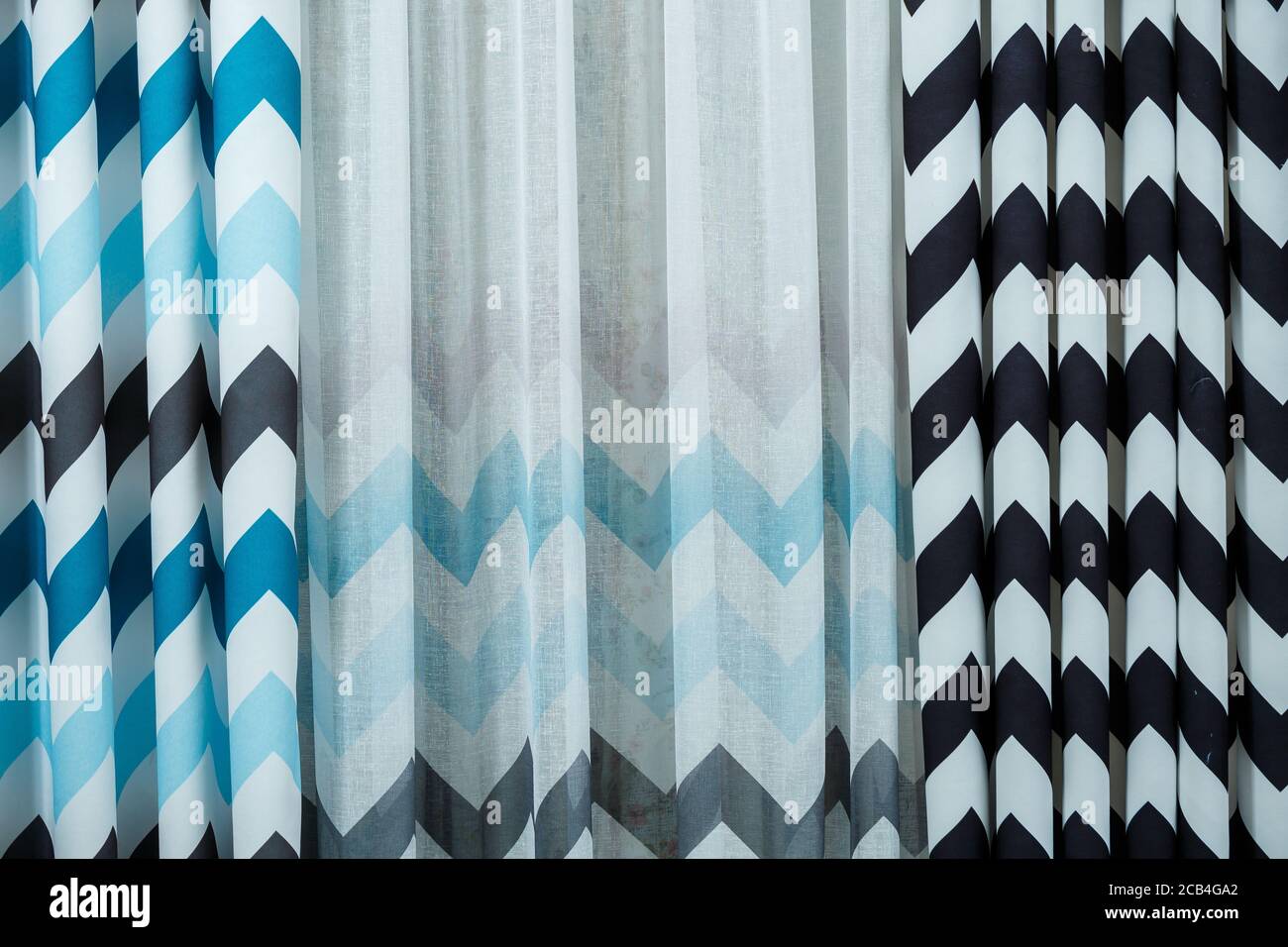 Curtain samples hanging from hangers on rail in store. Fabric texture ...