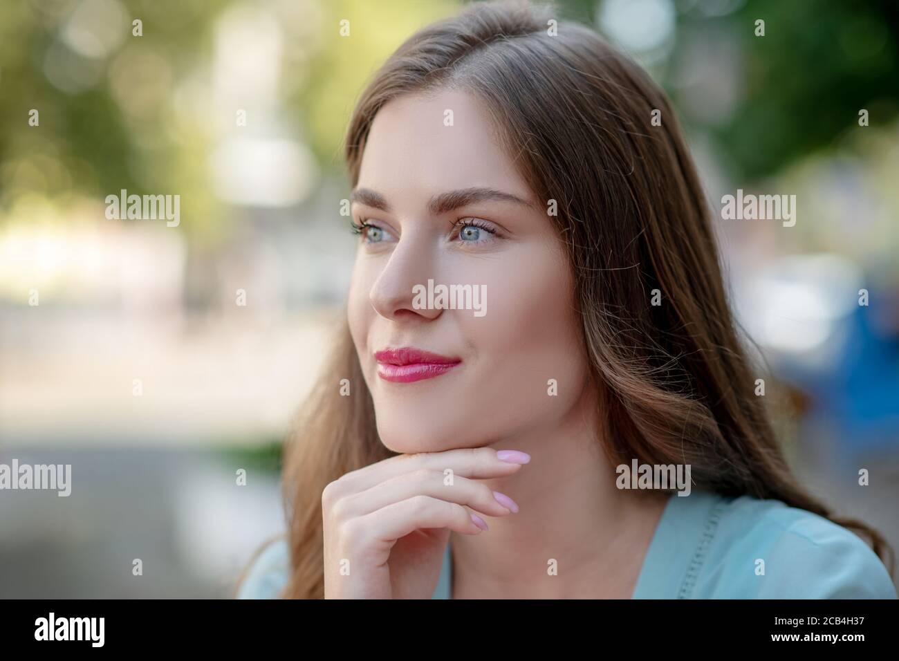Charming brown-haired female resting her chin on hand Stock Photo - Alamy