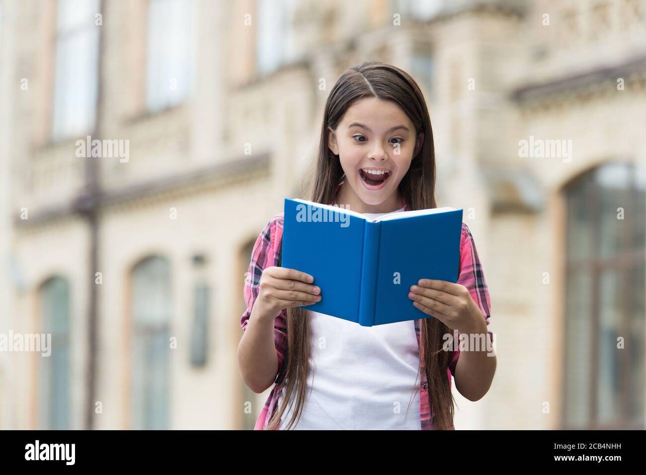 Discover something new. Happy child read book outdoors. Excited ...