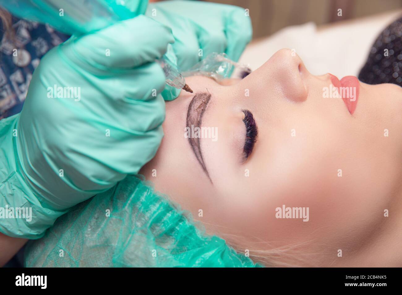 Micro blading eyebrows work flow in a beauty salon. Woman having her ...