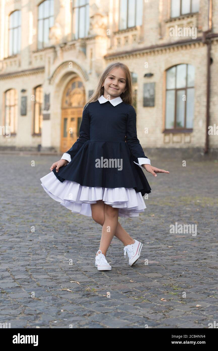 Its pleasure of elegance. Happy kid make curtsy in uniform outdoors ...