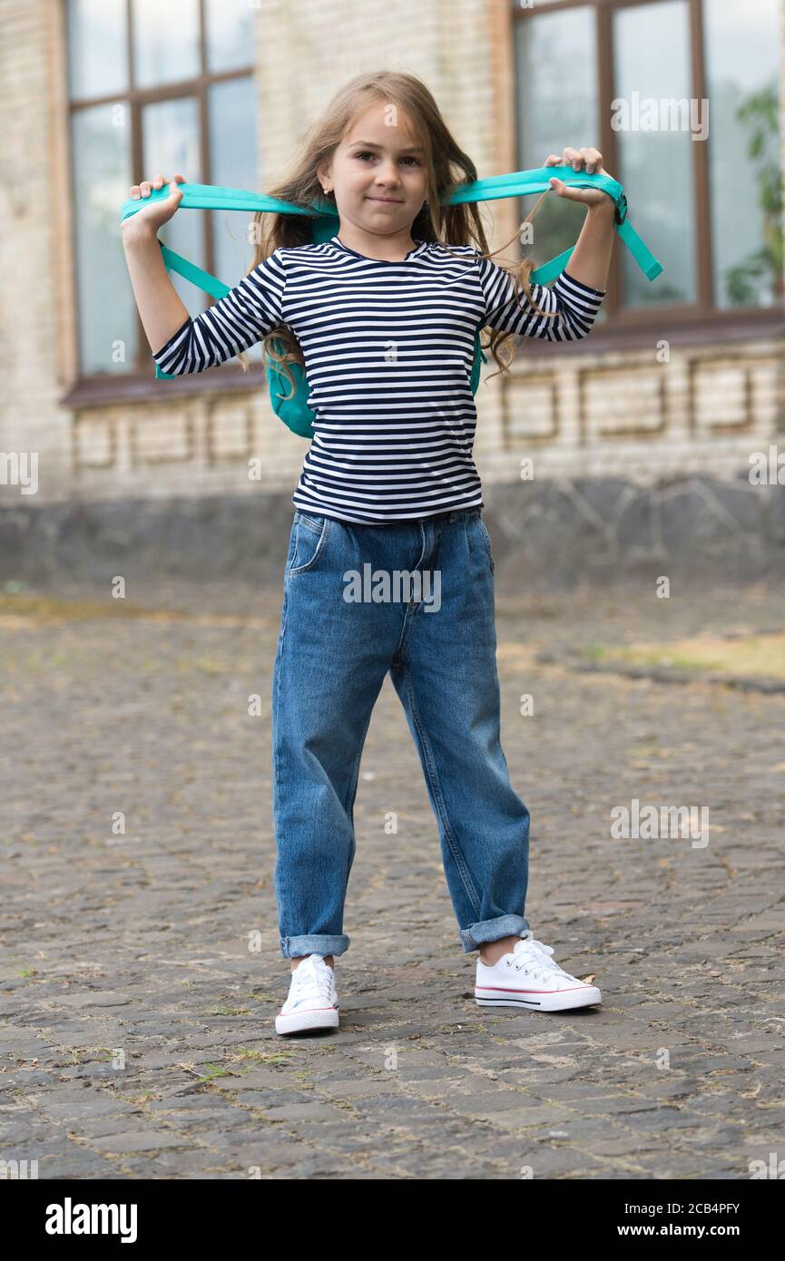 Early childhood education. Little child carry backpack outdoors. Happy ...