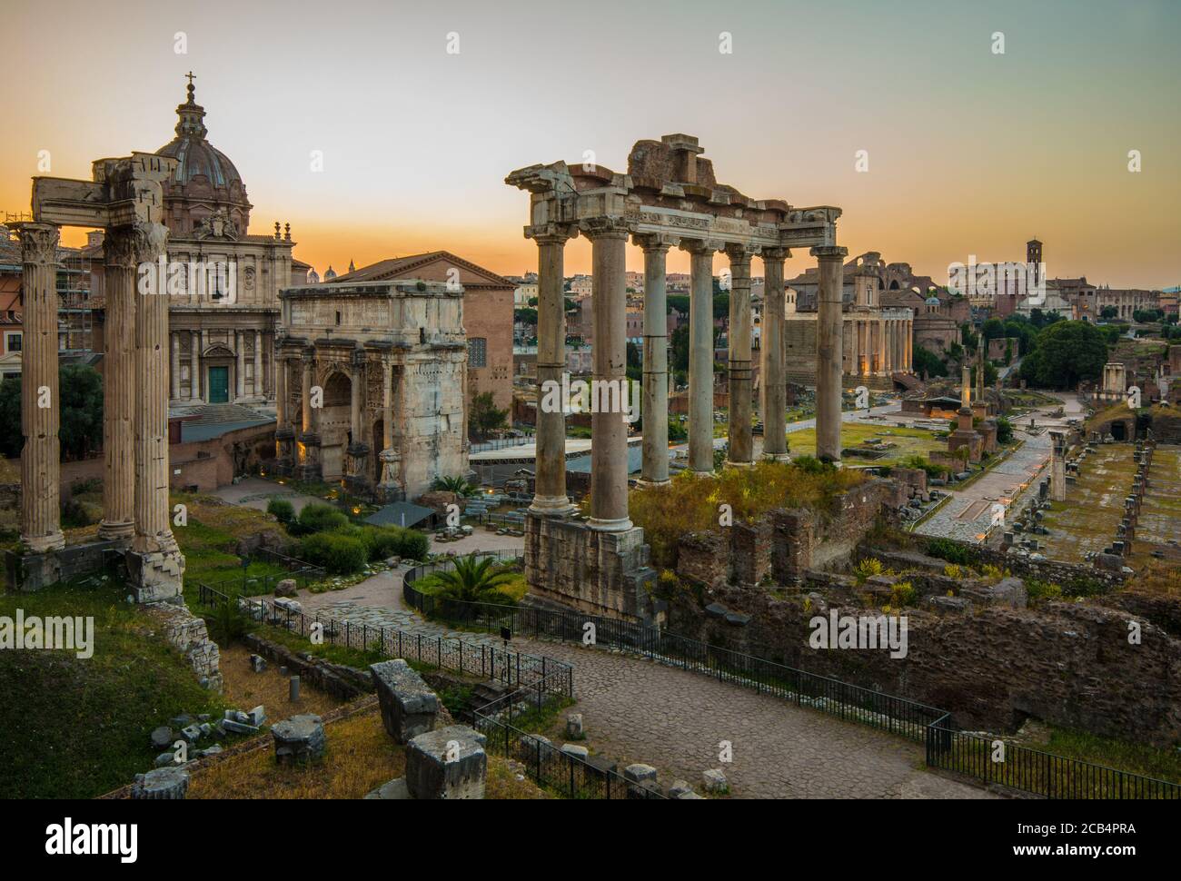 The sun rises over the Forum in Rome, Italy. The Colosseum can be seen ...