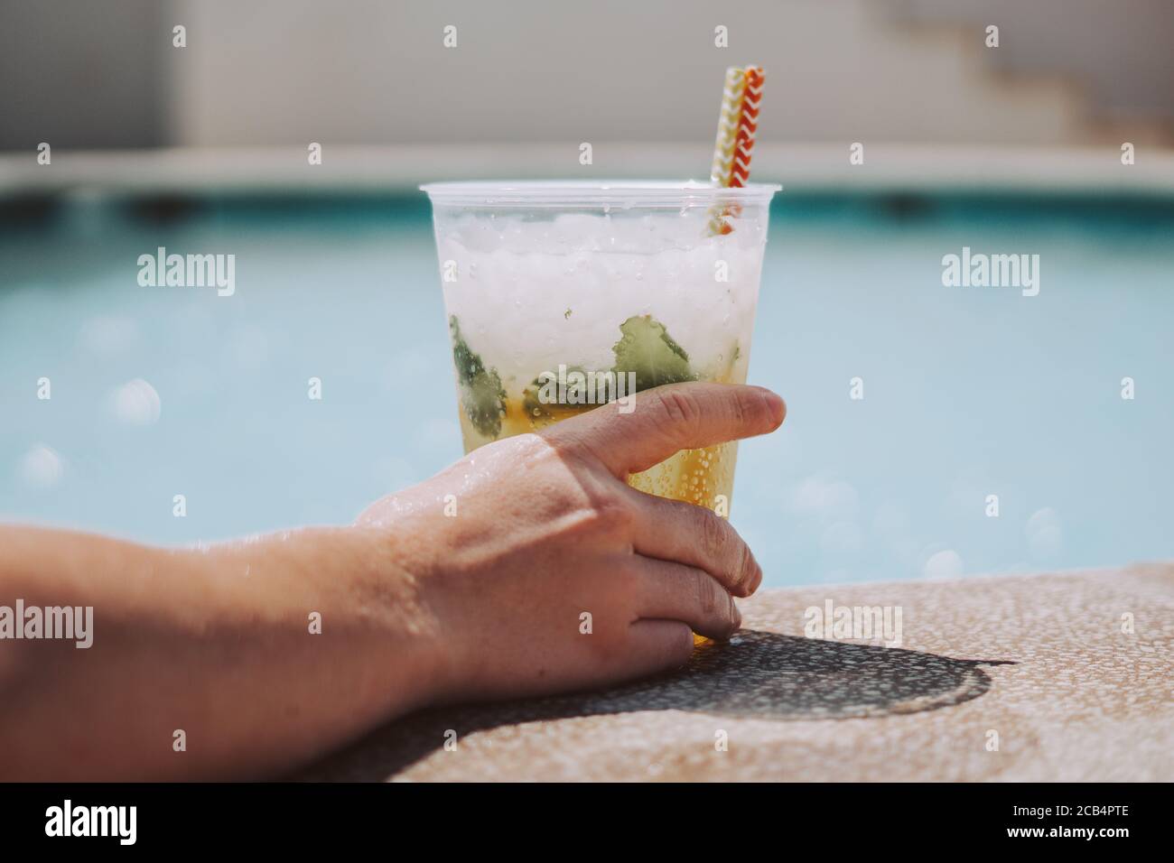 Shot of a hand holding a cup of a cold drink with small ice cubes and ...