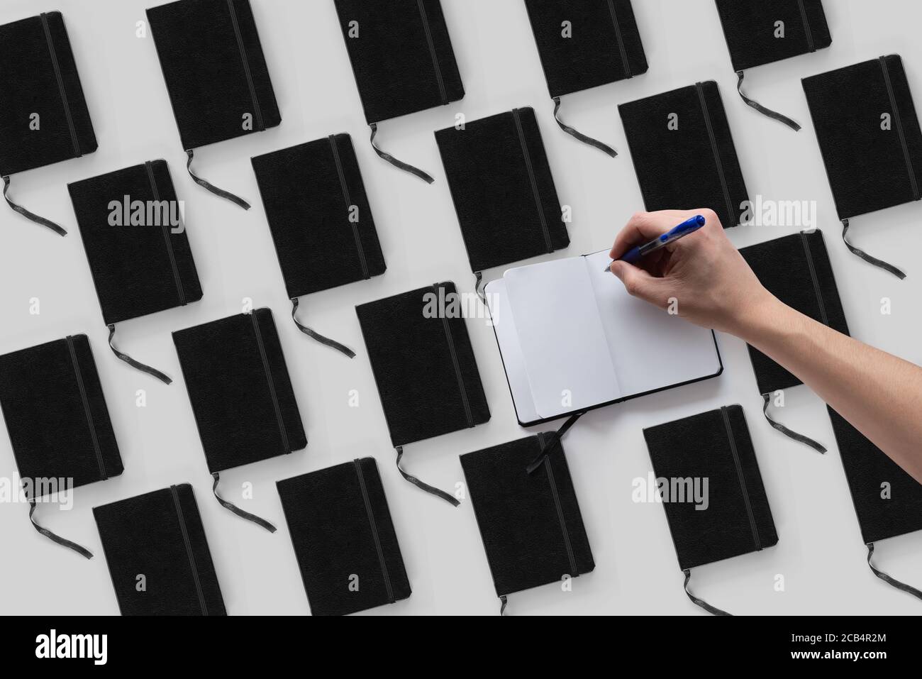 Flat lay of notebooks forming a texture. One of them is opened a hand ...
