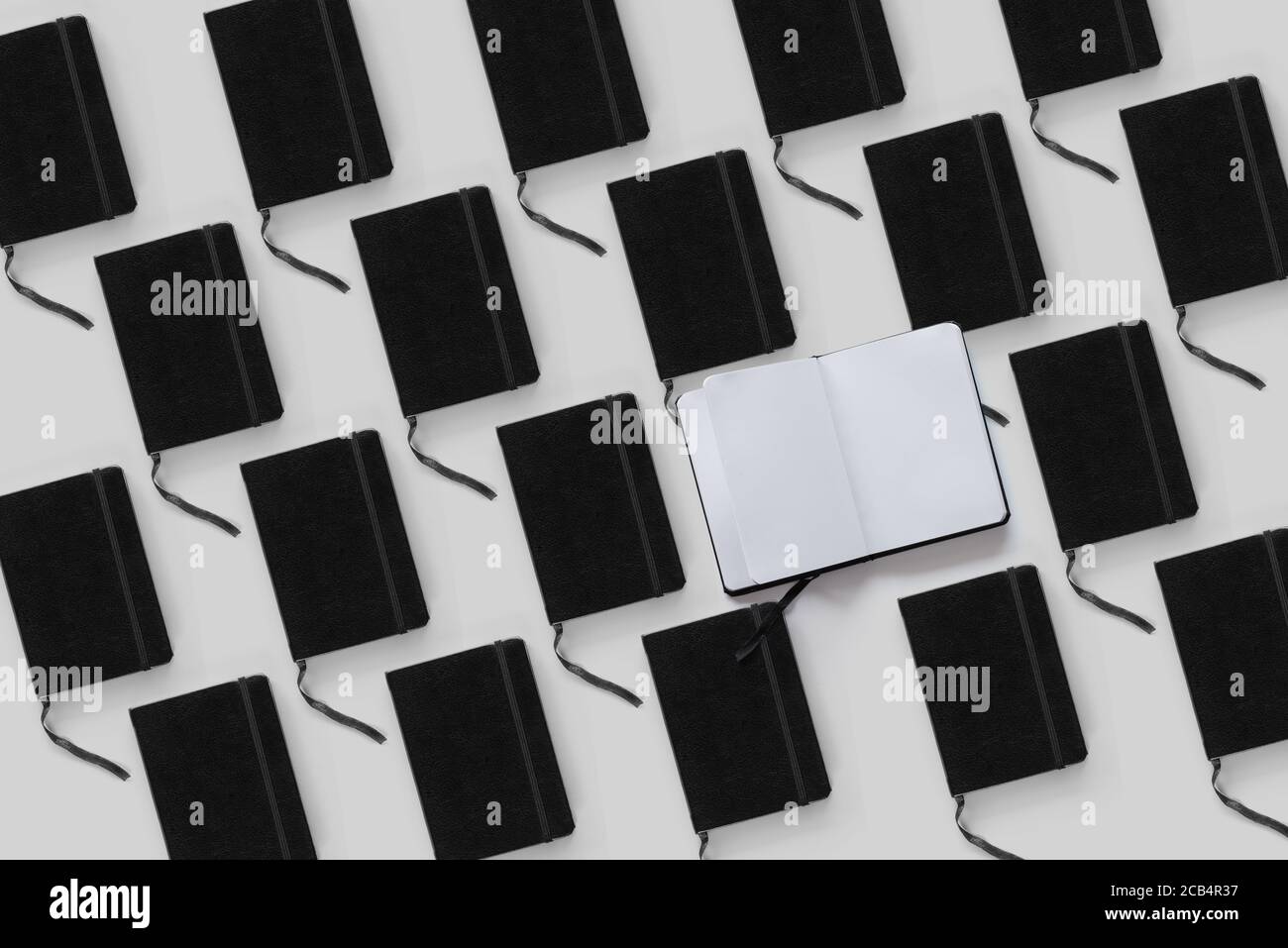 Flat lay of notebooks forming a texture. One of them is opened at a ...