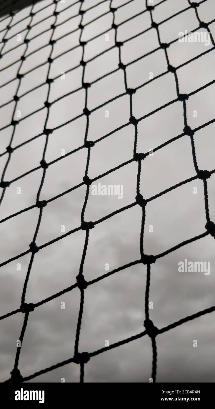 Closeup shot of a black net on a grey cloudy sky background Stock Photo ...