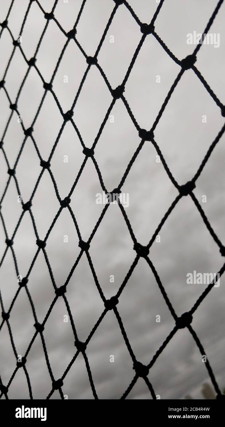 Closeup shot of a black net on a grey cloudy sky background Stock Photo ...