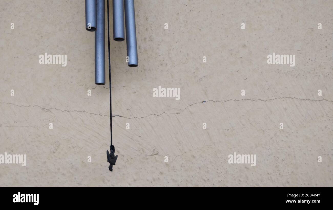 Closeup vertical shot of a wind chime on a white wall background Stock ...