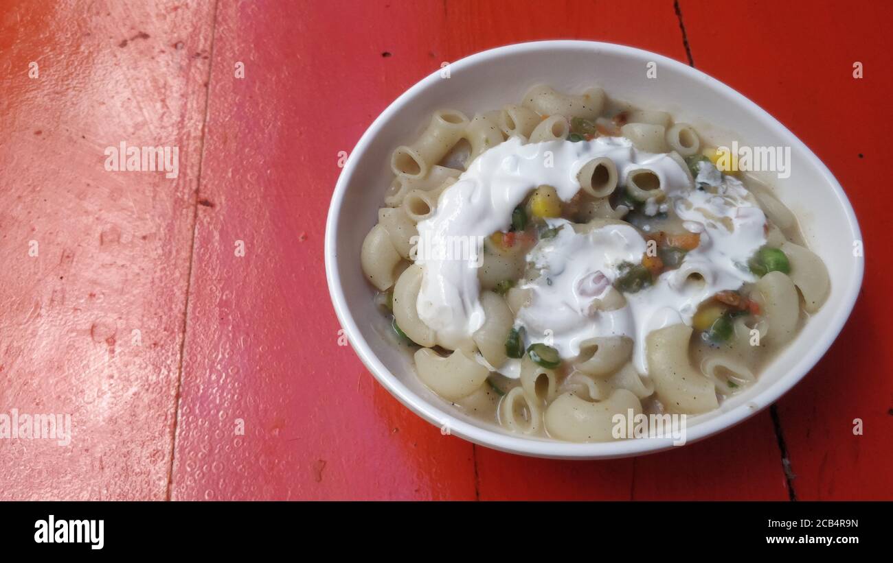 High angle shot of a tasty looking pasta on a red table Stock Photo - Alamy