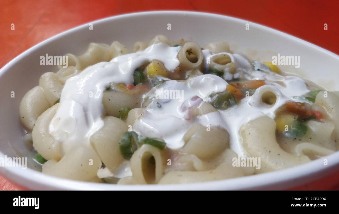 High angle shot of a tasty looking pasta on a red table Stock Photo - Alamy