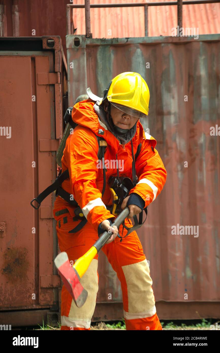 A portrait of Asian male fireman in orange protective clothing, mask ...