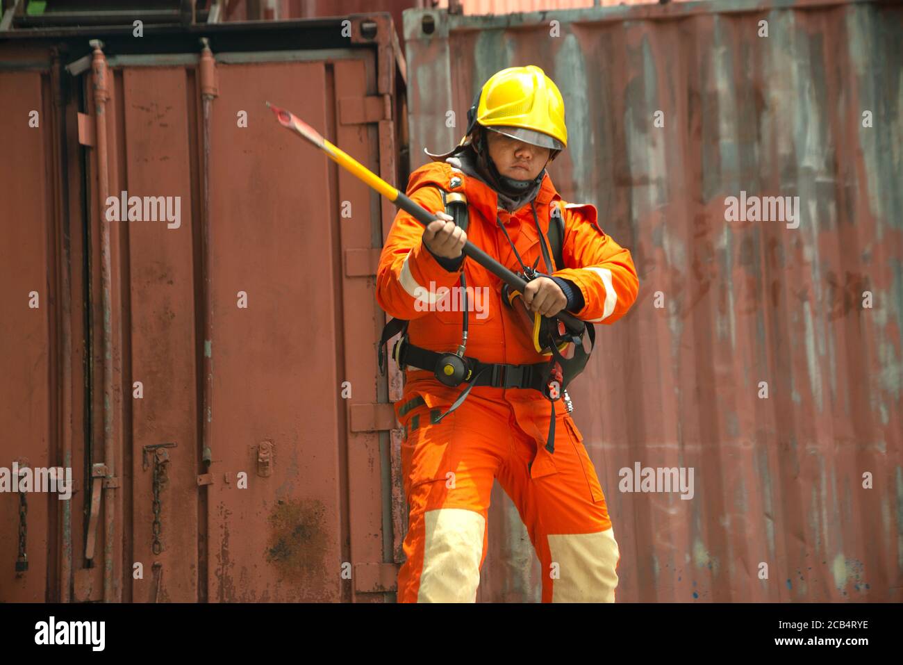 A portrait of Asian male fireman in orange protective clothing, mask ...