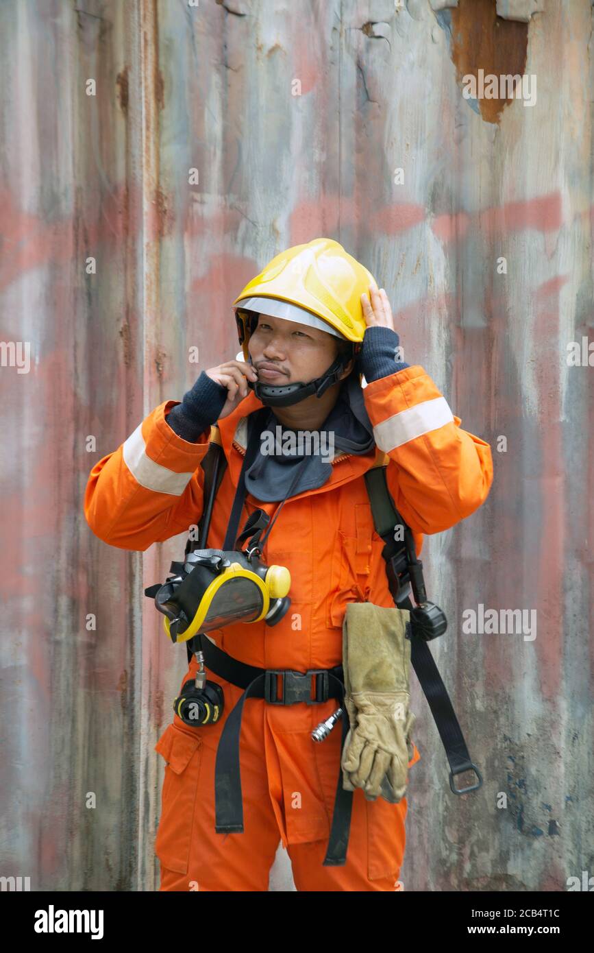 The portrait of Asian firefighters are wearing orange fire protection ...