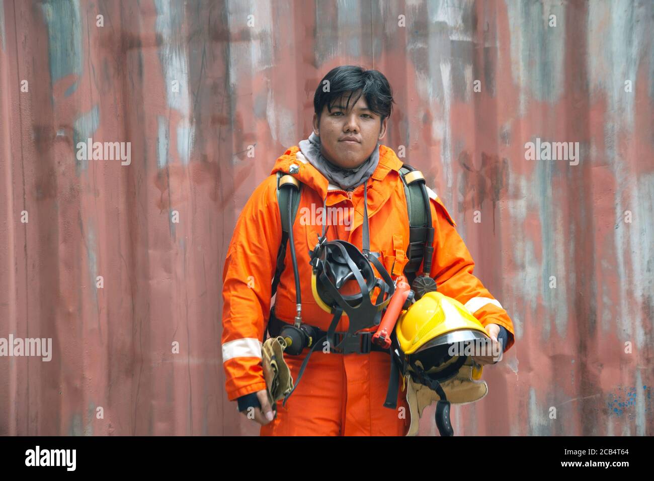 The portrait of young Asian firefighters are wearing orange fire ...