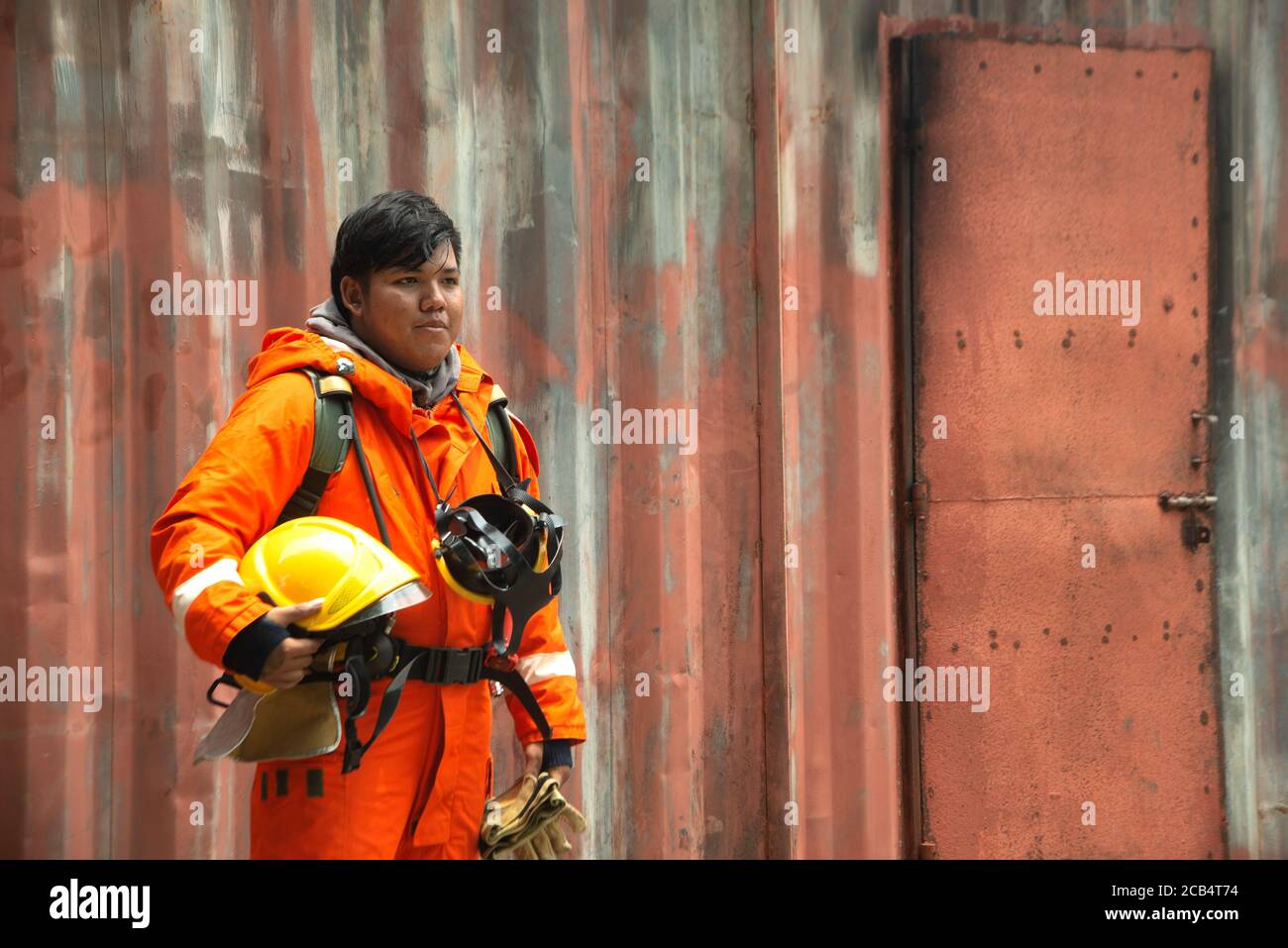 The portrait of young Asian firefighters are wearing orange fire ...