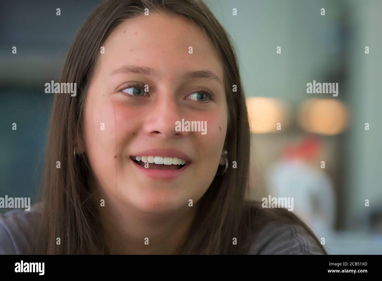 Young woman smiles in mid conversation Stock Photo - Alamy