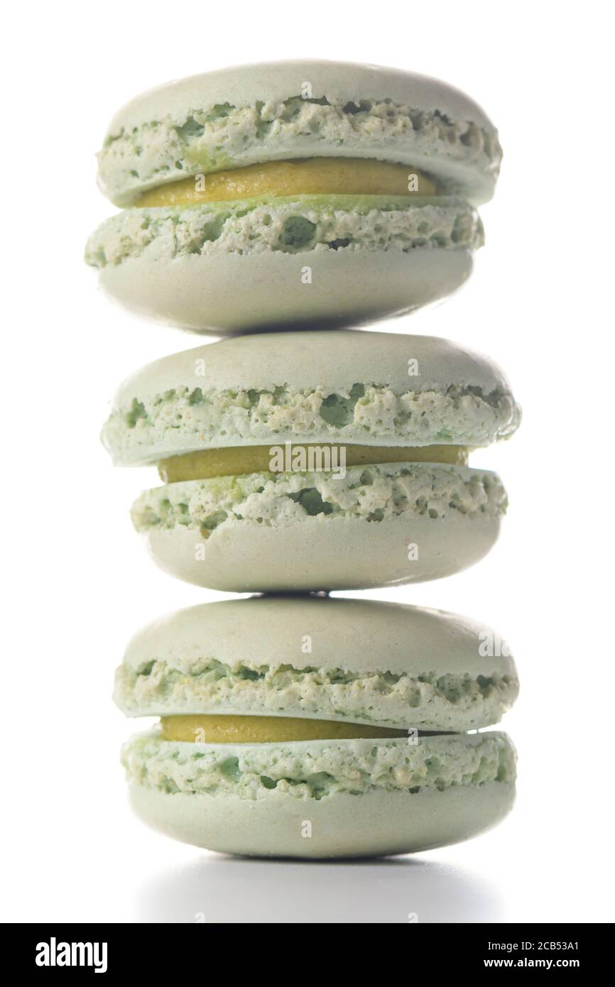 Three mint flavoured macaroons standing on top of each other on white ...
