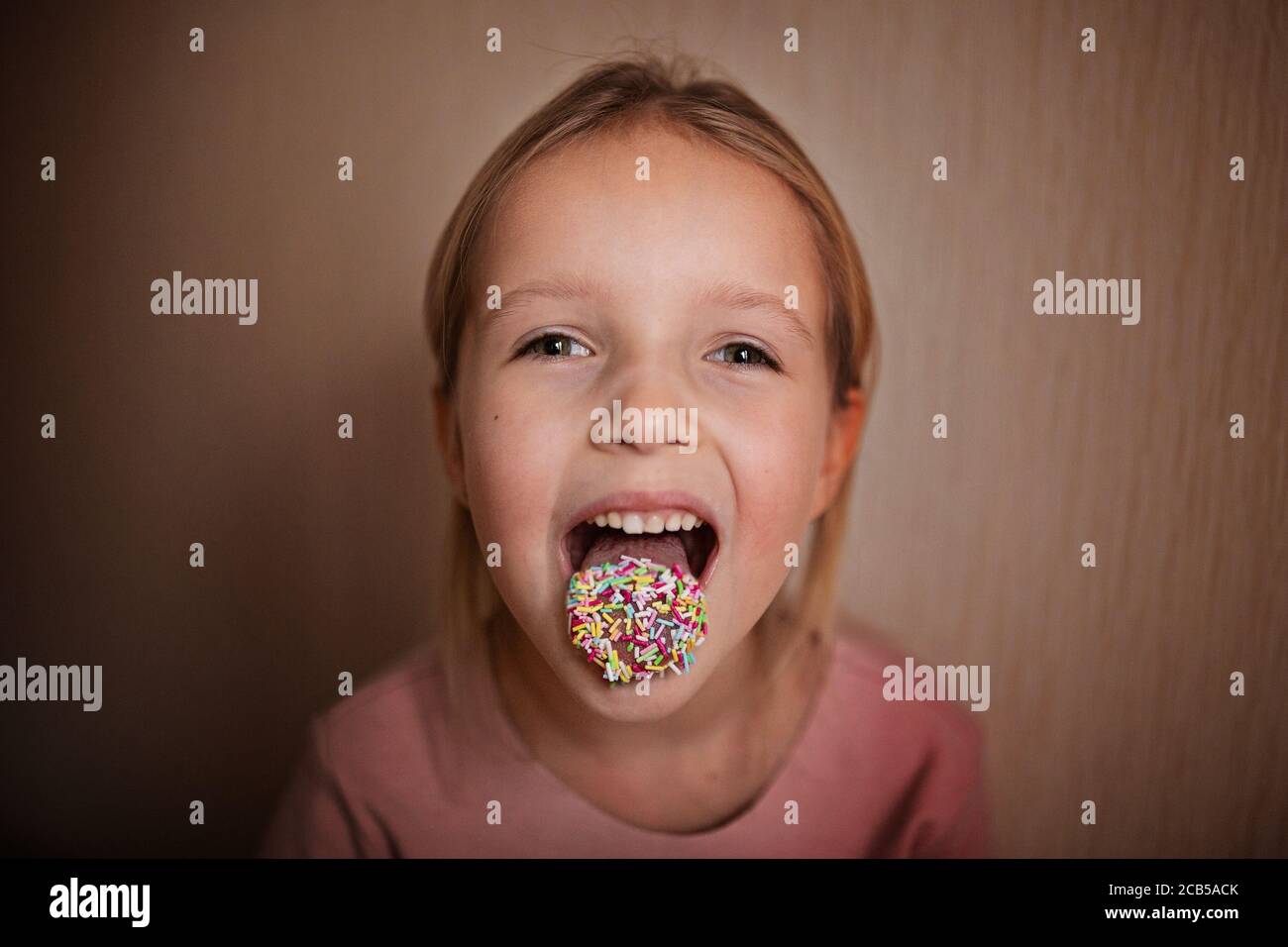 Funny child with candy on tongue, lifestyle photo of happy blonde ...