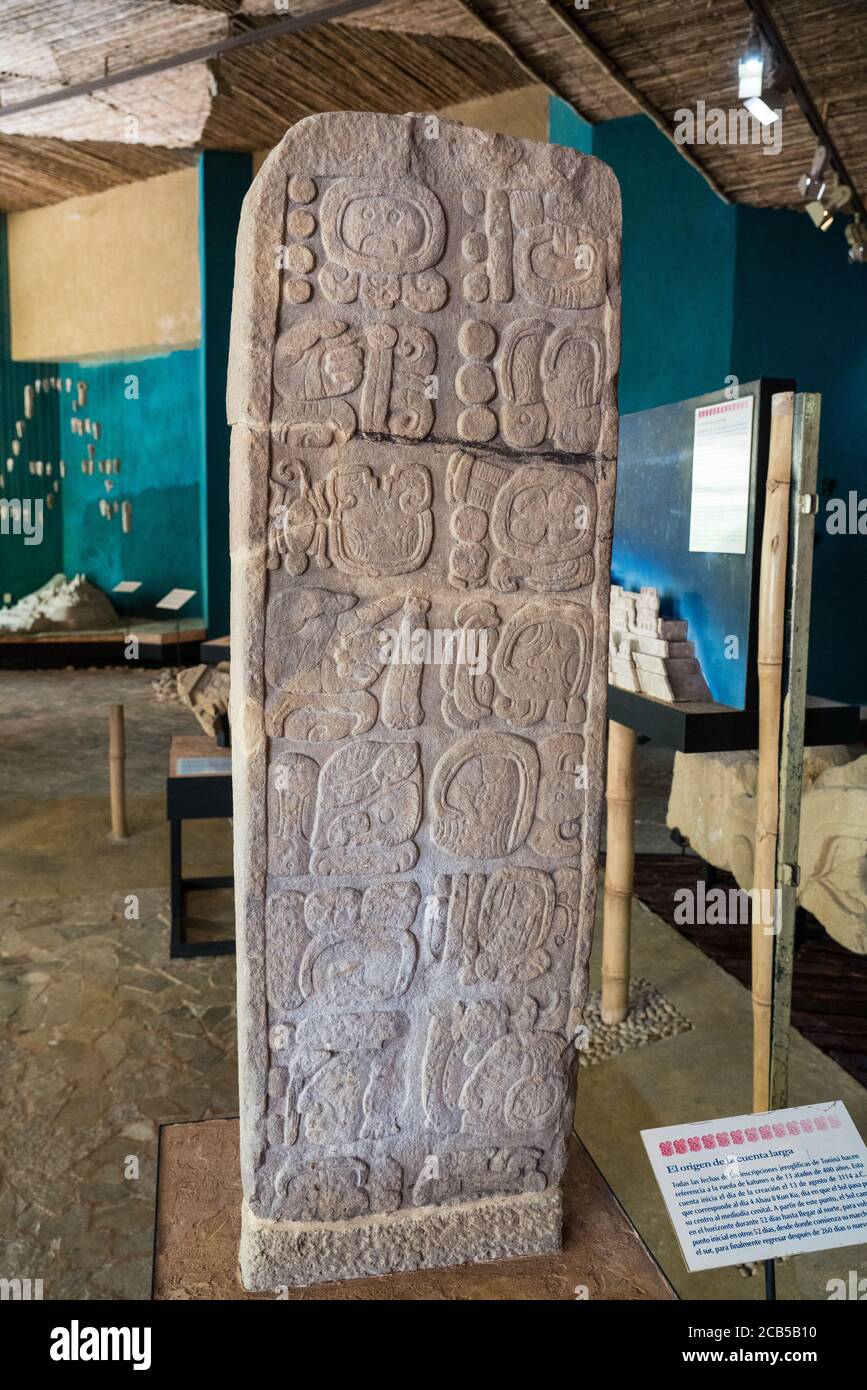 A carved stone stela with glyphs in the museum at the ruins of the ...