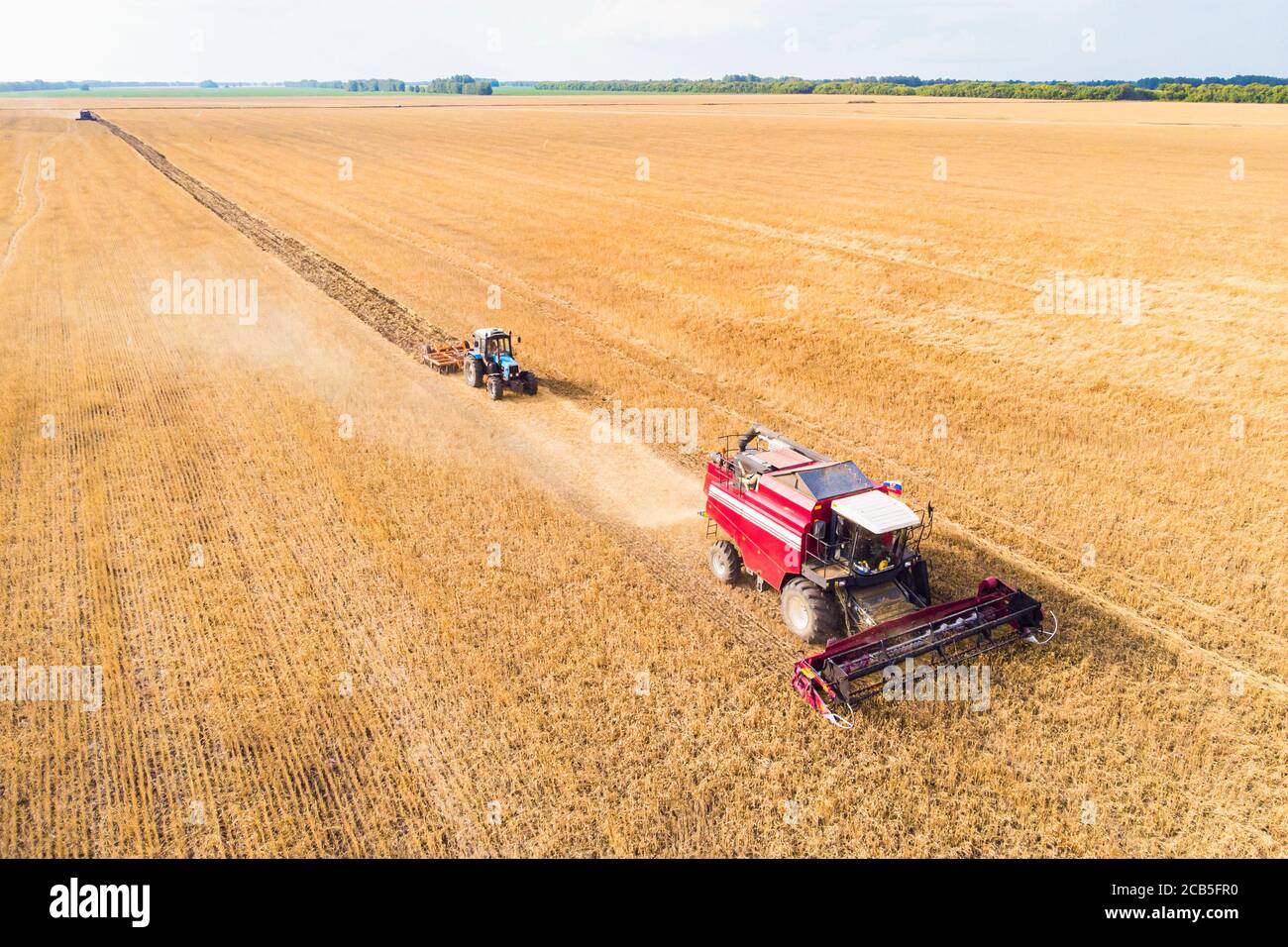 Agriculture machine harvesting crop in fields. Tractor pulls a ...