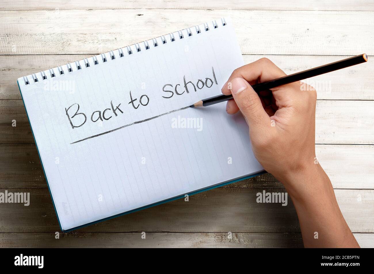 Hand with pencil writing in the book. Back to School concept Stock ...