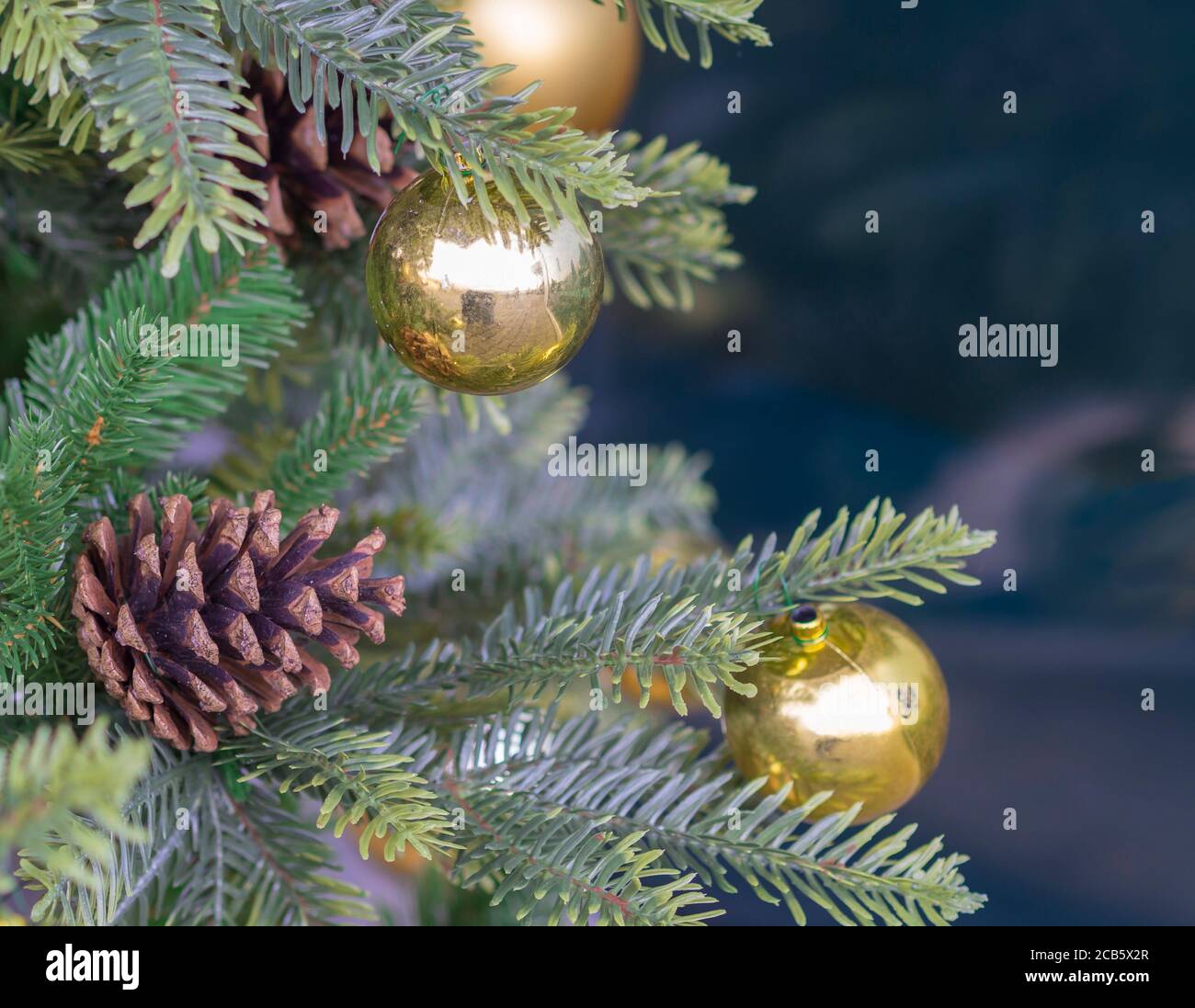 close up pine tree cone and golden christmas balls on artificial ...