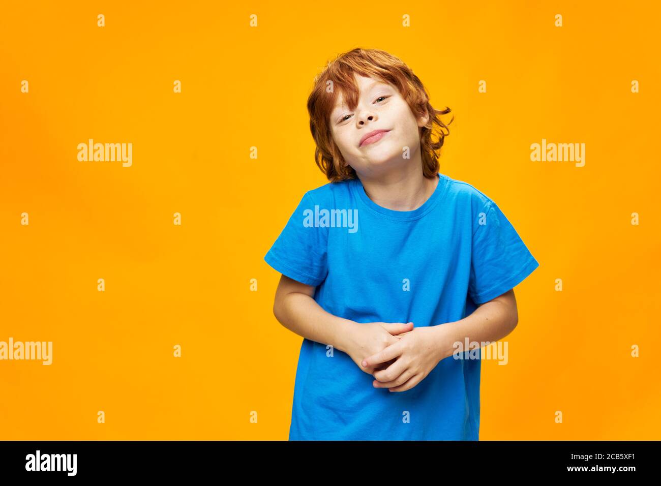 boy red hair blue t-shirt yellow isolated background freckles and ...