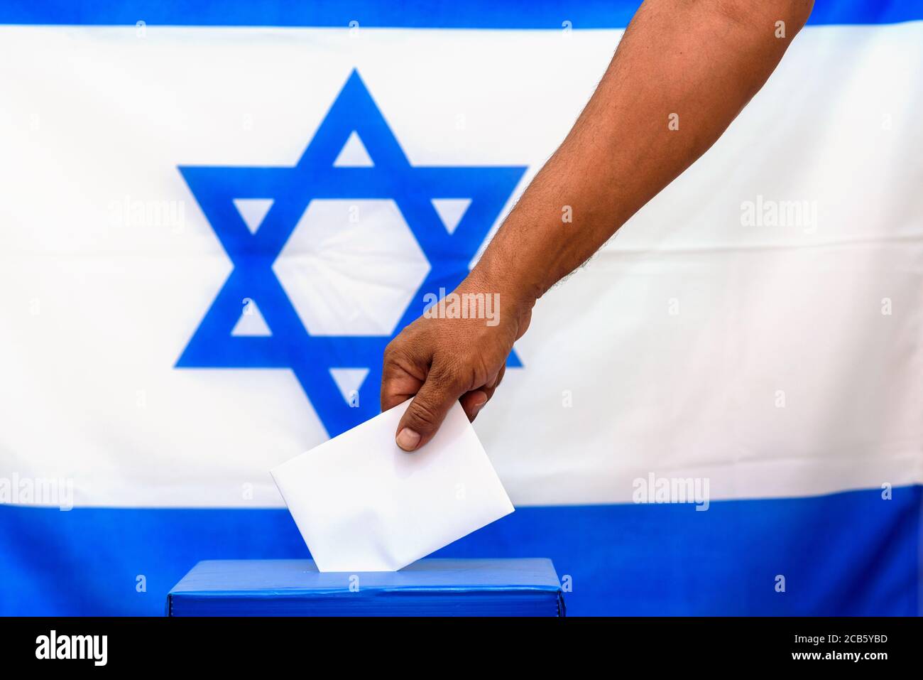 Israeli man putting a ballot in a ballot box on election day. Close up ...