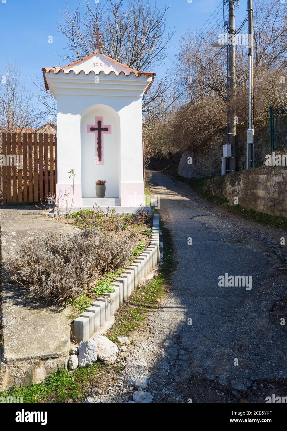 small white wayside shrine, road blessing or Gods torture with cross ...