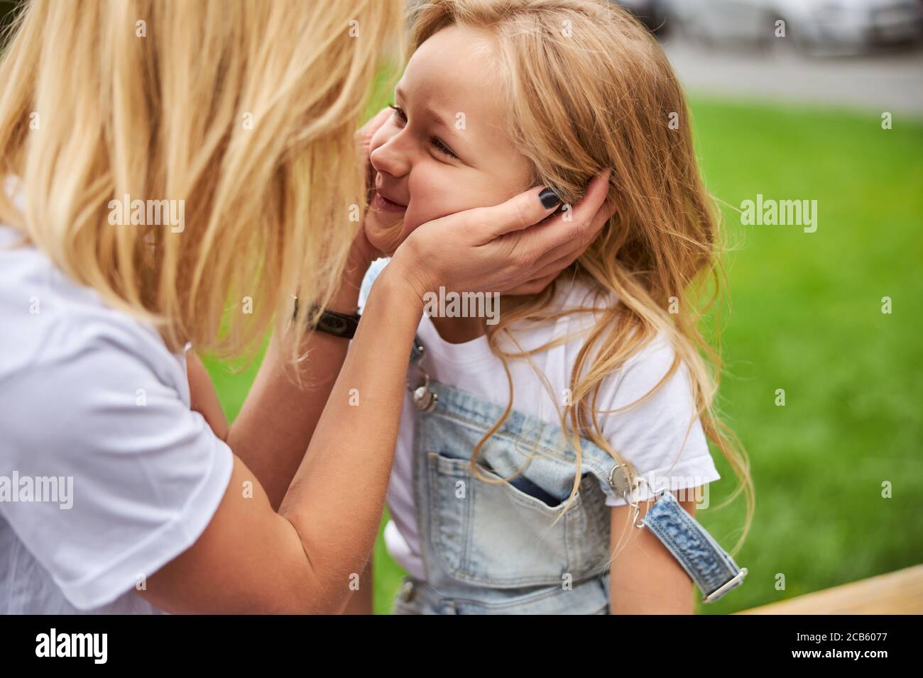 Female touching head of little girl with her hands Stock Photo - Alamy
