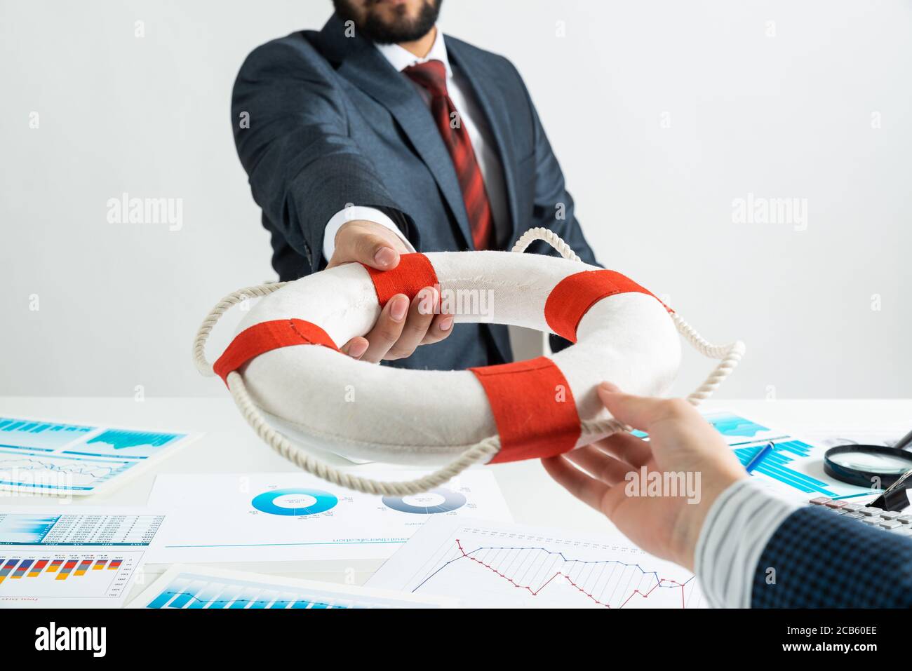 Business persons holding small lifebuoy together Stock Photo - Alamy