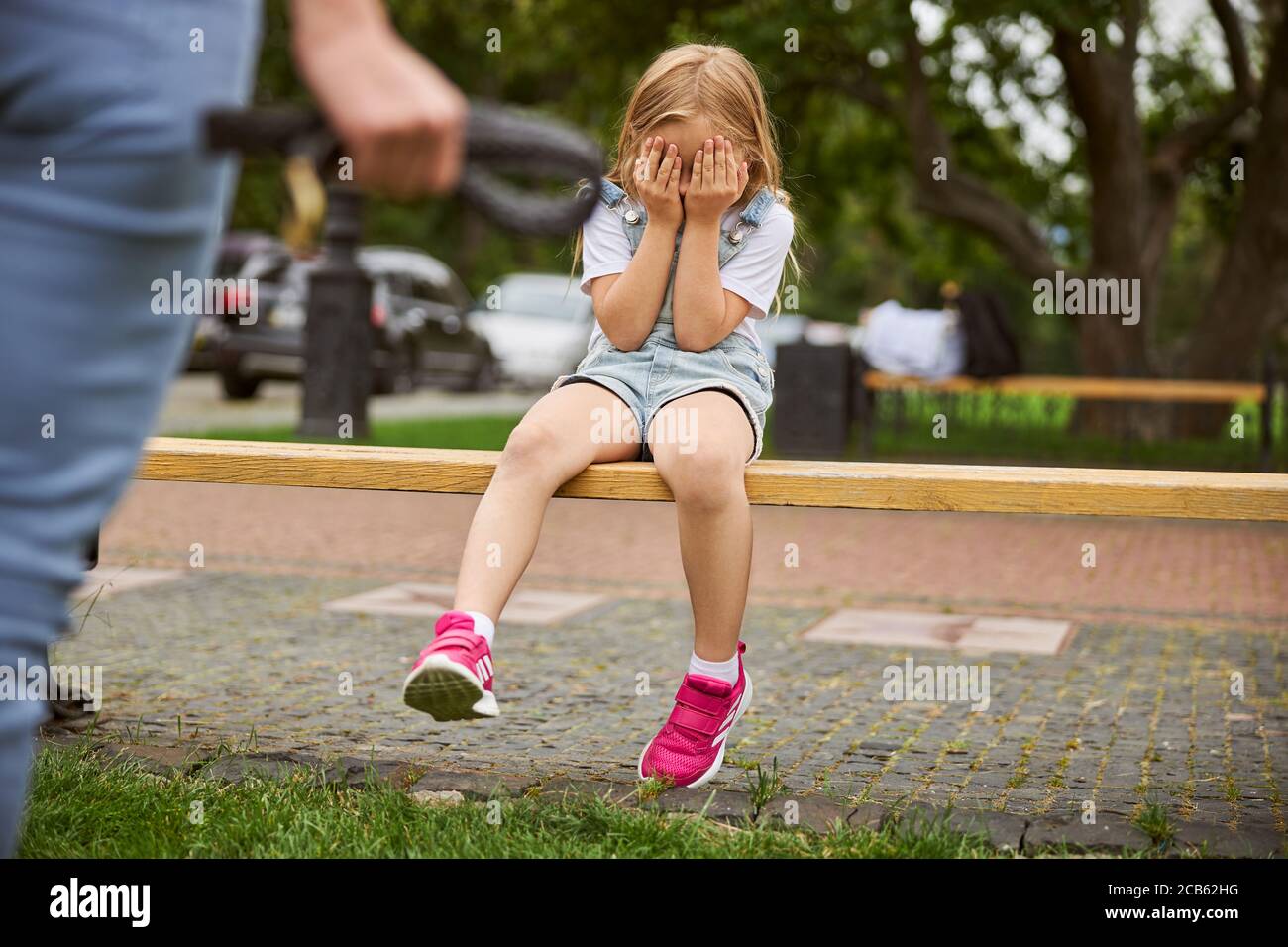 Crying little girl holding hands on the face Stock Photo - Alamy