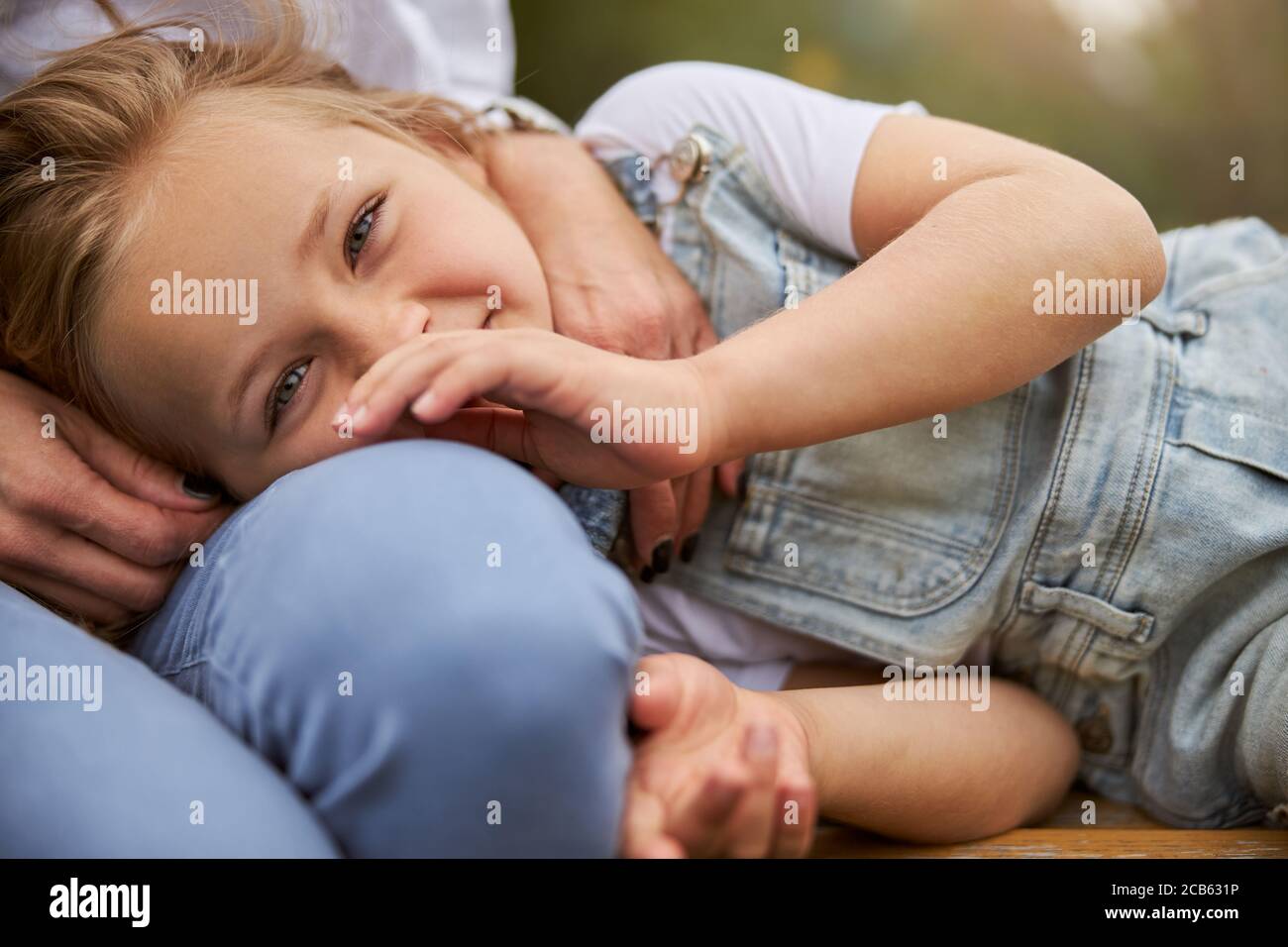 Very happy female child putting head on the legs of woman Stock Photo ...
