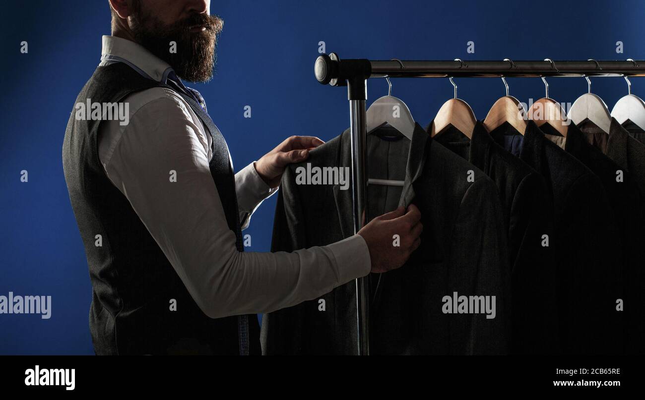 Elegant man's suits hanging in a row. Luxury man classic suits on rack ...