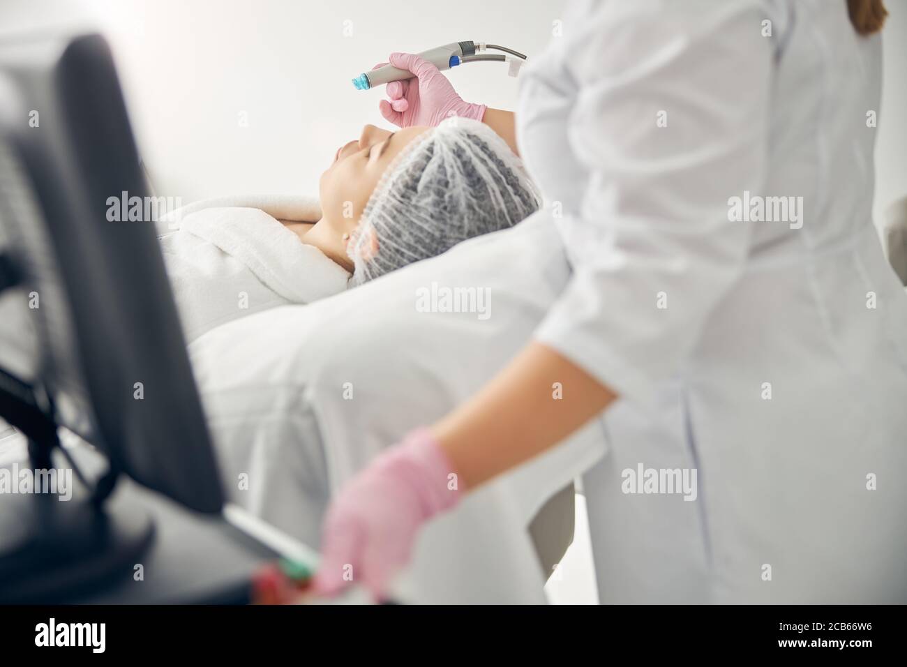 Female doctor treating a woman using a beauty machine Stock Photo - Alamy