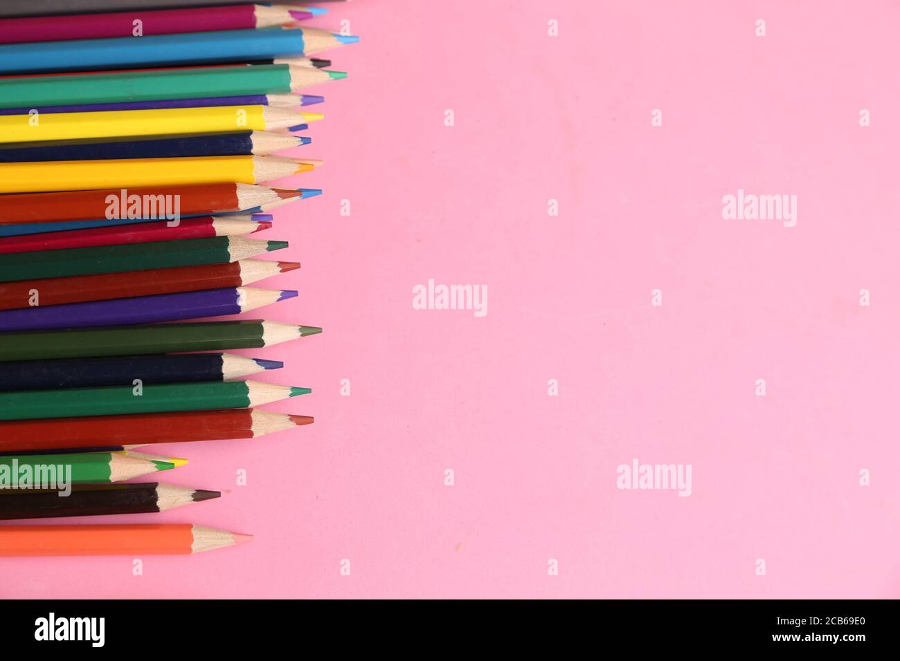 Overhead shot of colored pencils on the side on a pink surface Stock ...