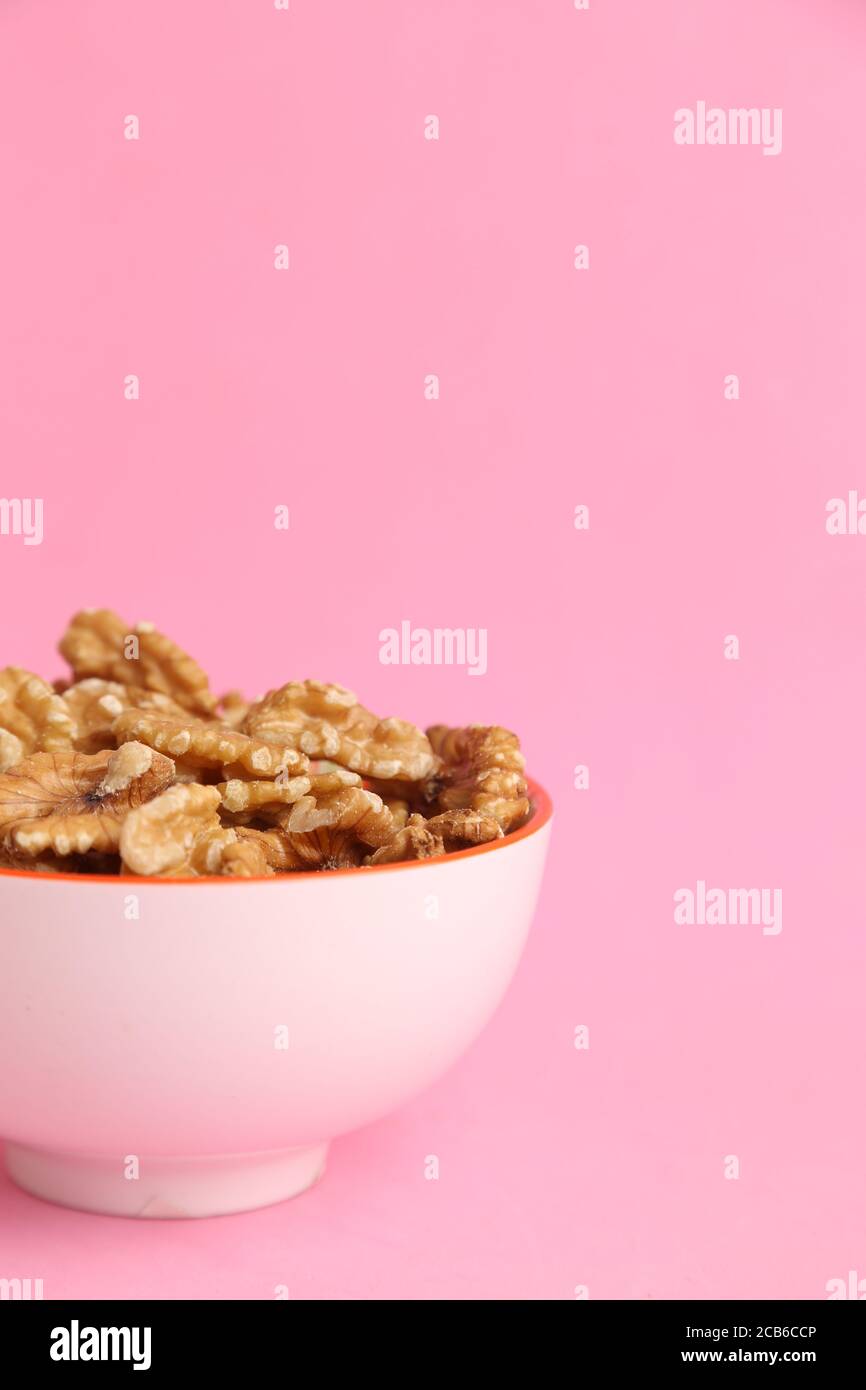 Closeup shot of the delicious walnuts in the bowl on the pink ...