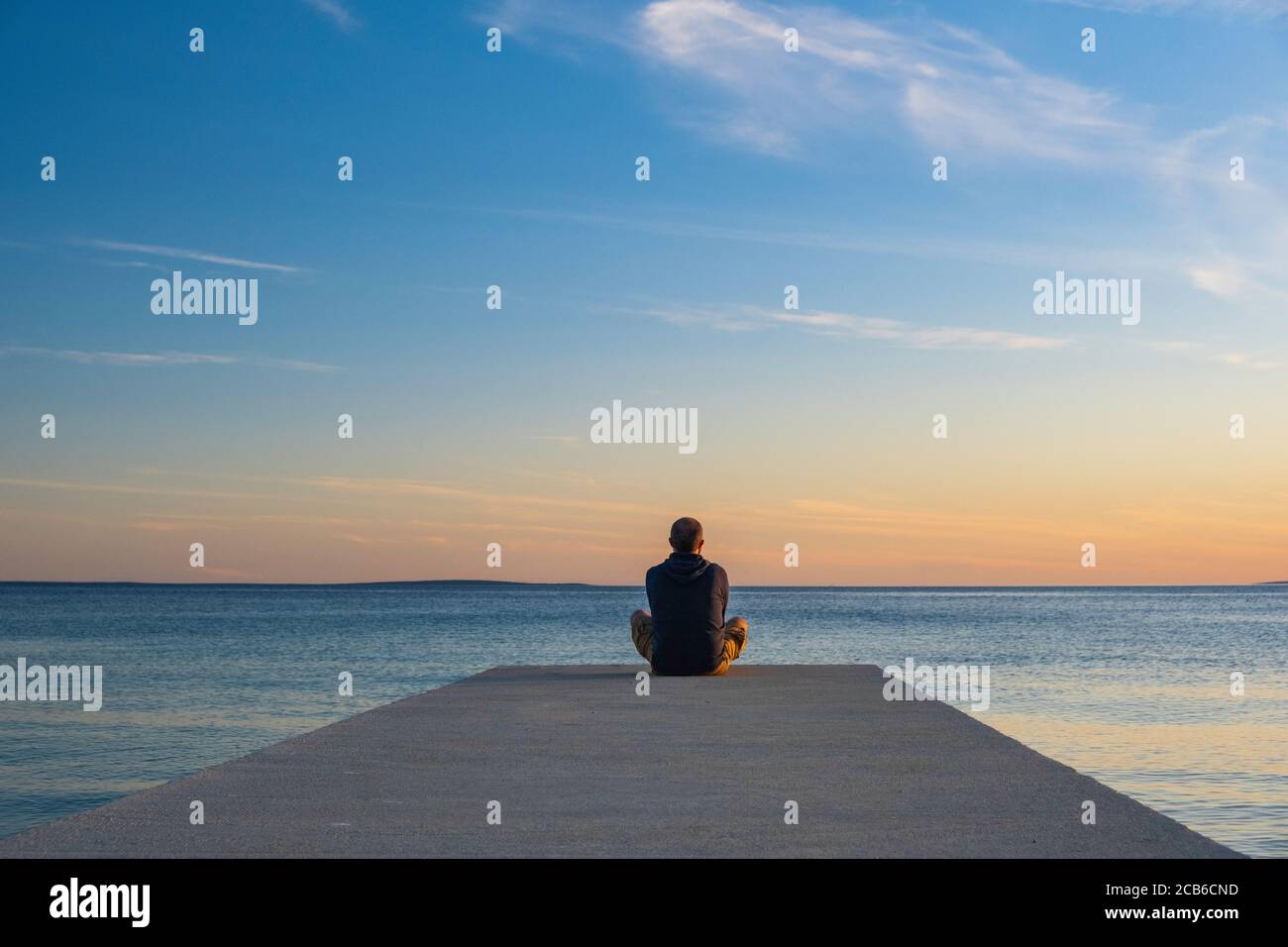 Man sitting on dock hi-res stock photography and images - Alamy