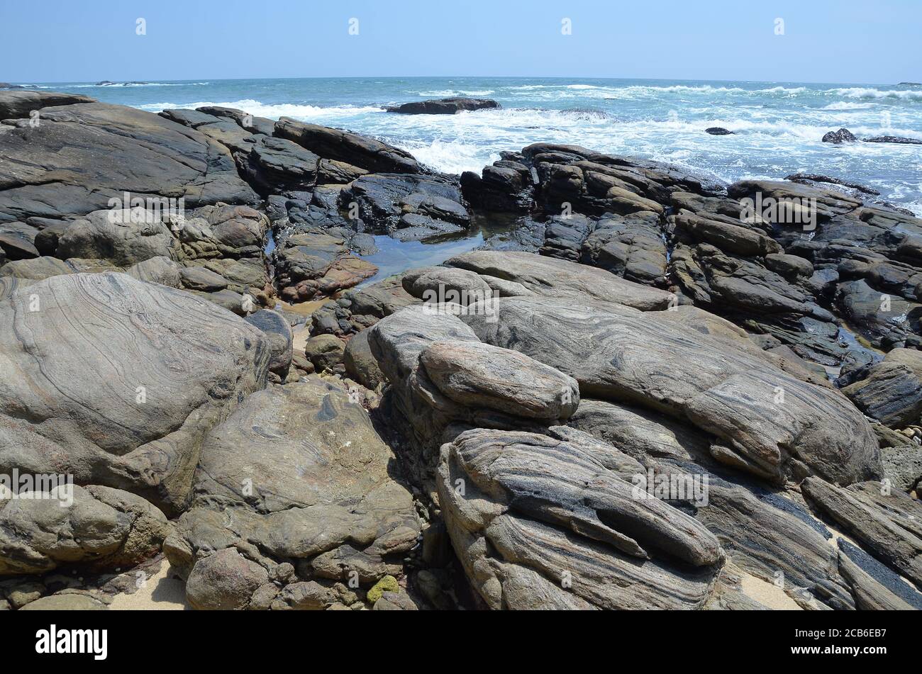 Beautiful scenery of rock formations on the beach with splashing sea ...