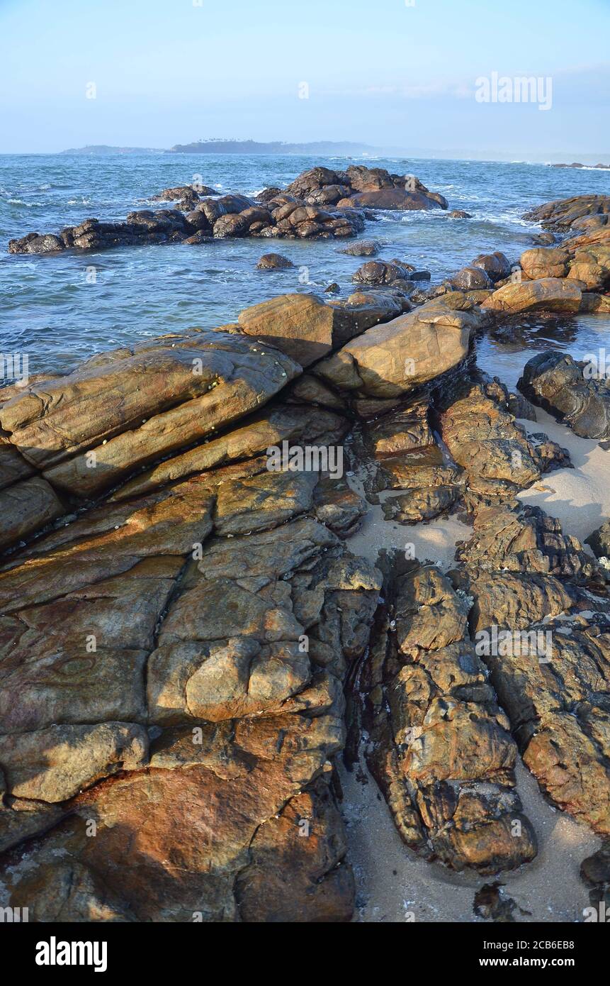 Beautiful scenery of rock formations on the beach with splashing sea ...