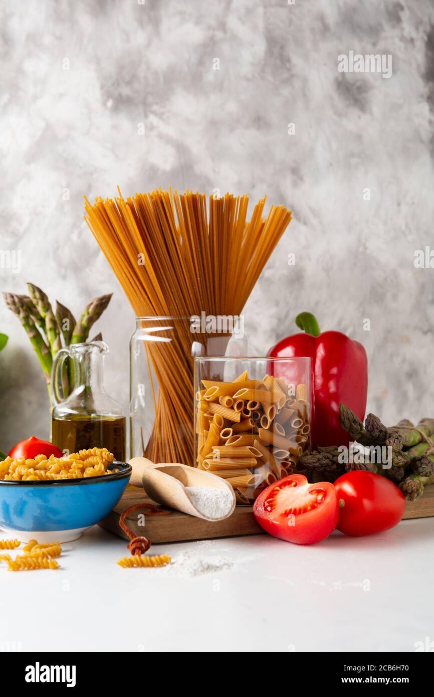 Whole spaghetti and penne in glass jar, fresh vegetables Stock Photo ...