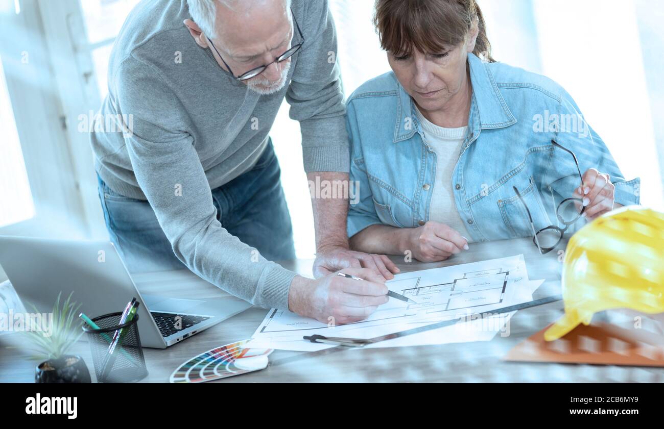 Architects working on blueprint of new construction project; light ...