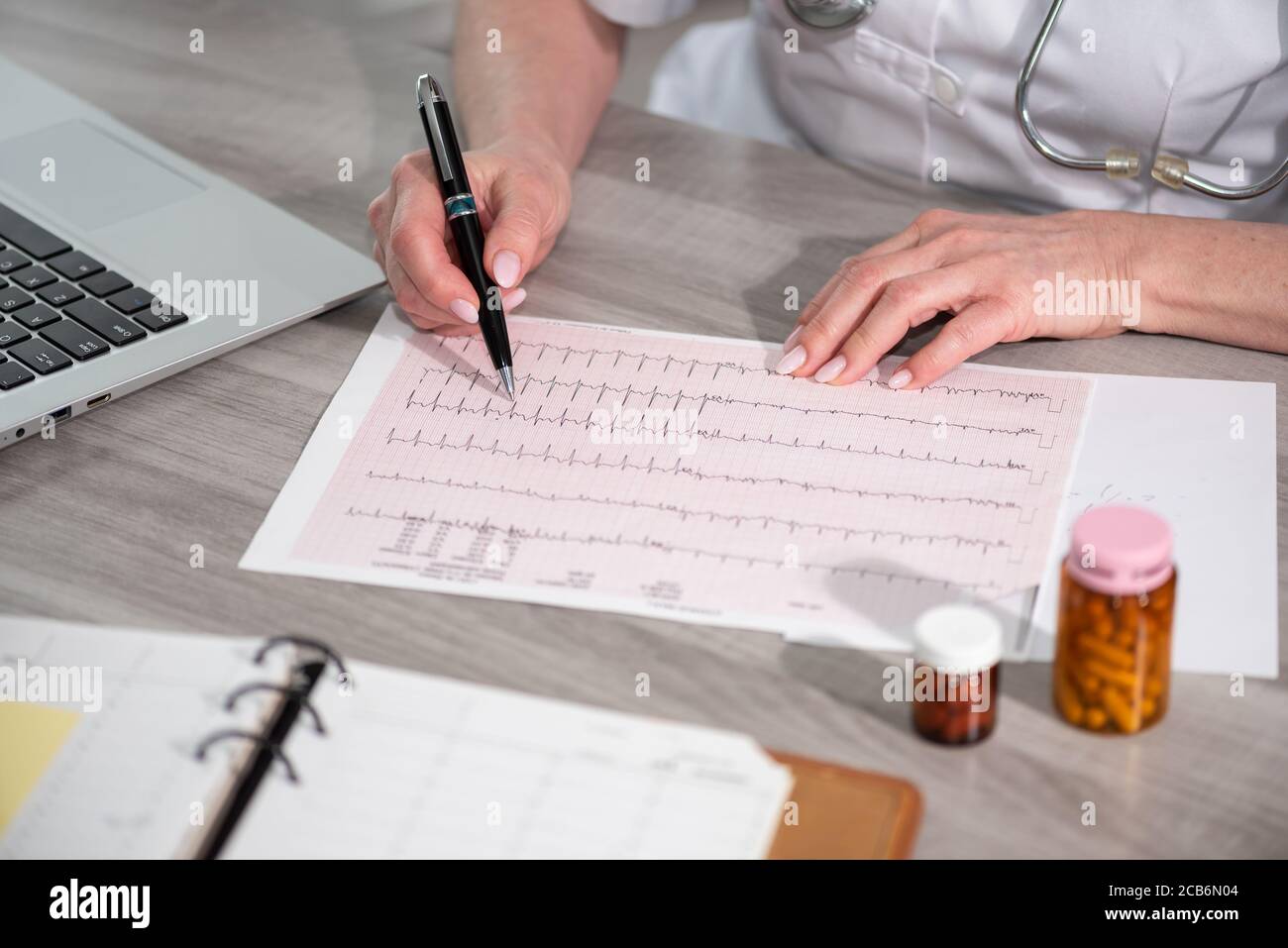 Female cardiologist examining an ecg graph in medical office Stock ...