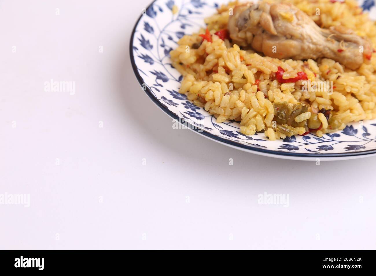 Closeup shot of curry rice and a chicken leg in a decorative plate on a ...